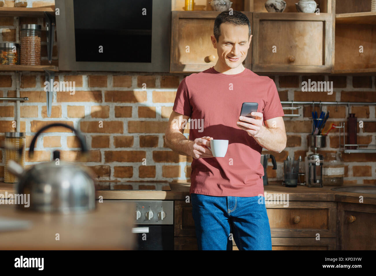Attractive brunette man reading incoming message Stock Photo - Alamy