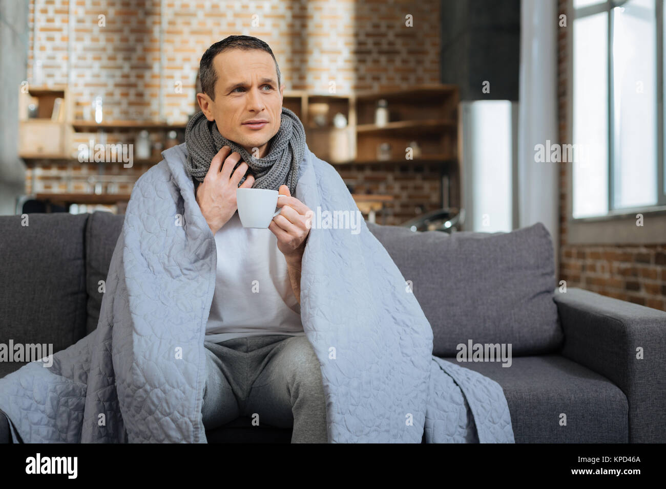Attractive man sitting in his living-room Stock Photo - Alamy
