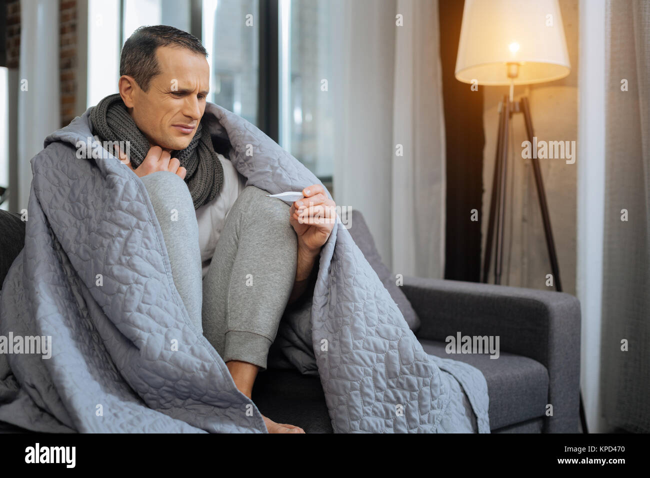 Attentive male person checking his temperature Stock Photo - Alamy