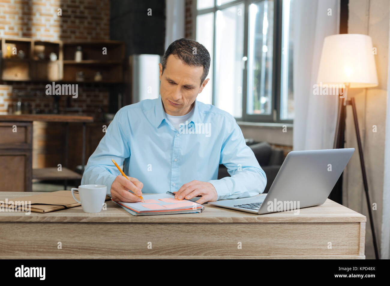 Serious male person making notes Stock Photo - Alamy