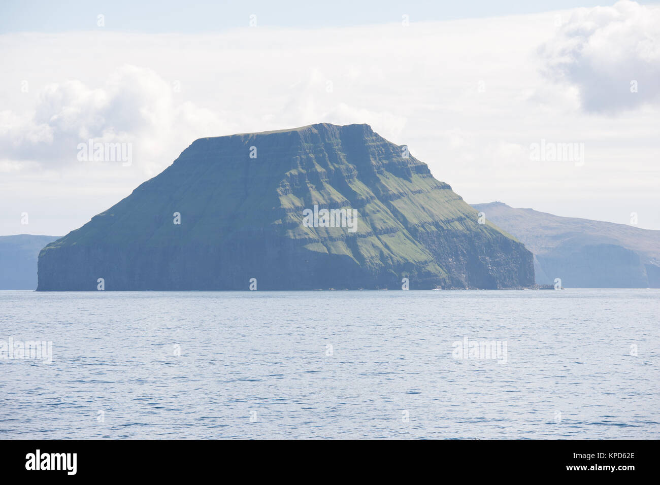 Typical landscape on the Faroe Islands, with green grass and rocks ...