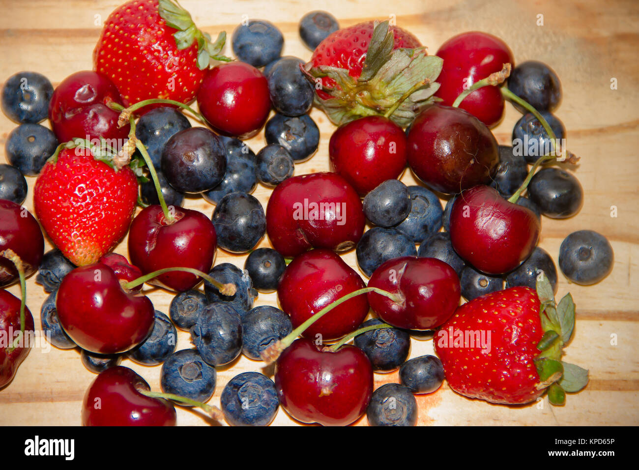 red fruits with rustic wood background Stock Photo - Alamy