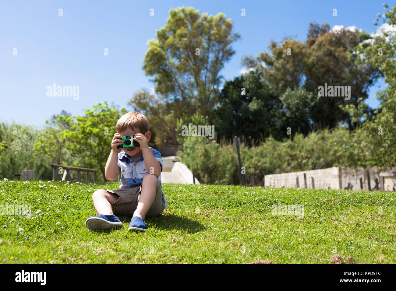 Kid with camera outdoors taking his first photo Stock Photo - Alamy