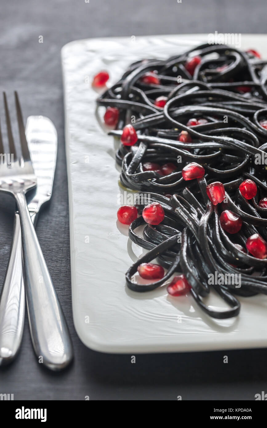Black pasta with pomegranate seeds Stock Photo - Alamy