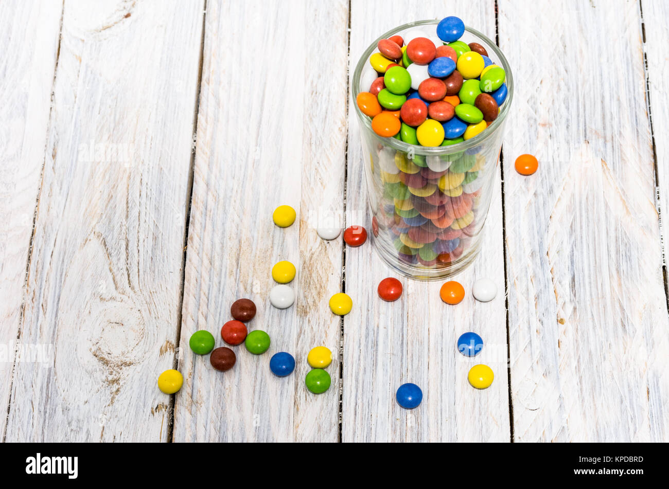 Stuffed glass. Crowded glass. Many multi-colored sweets. White ...