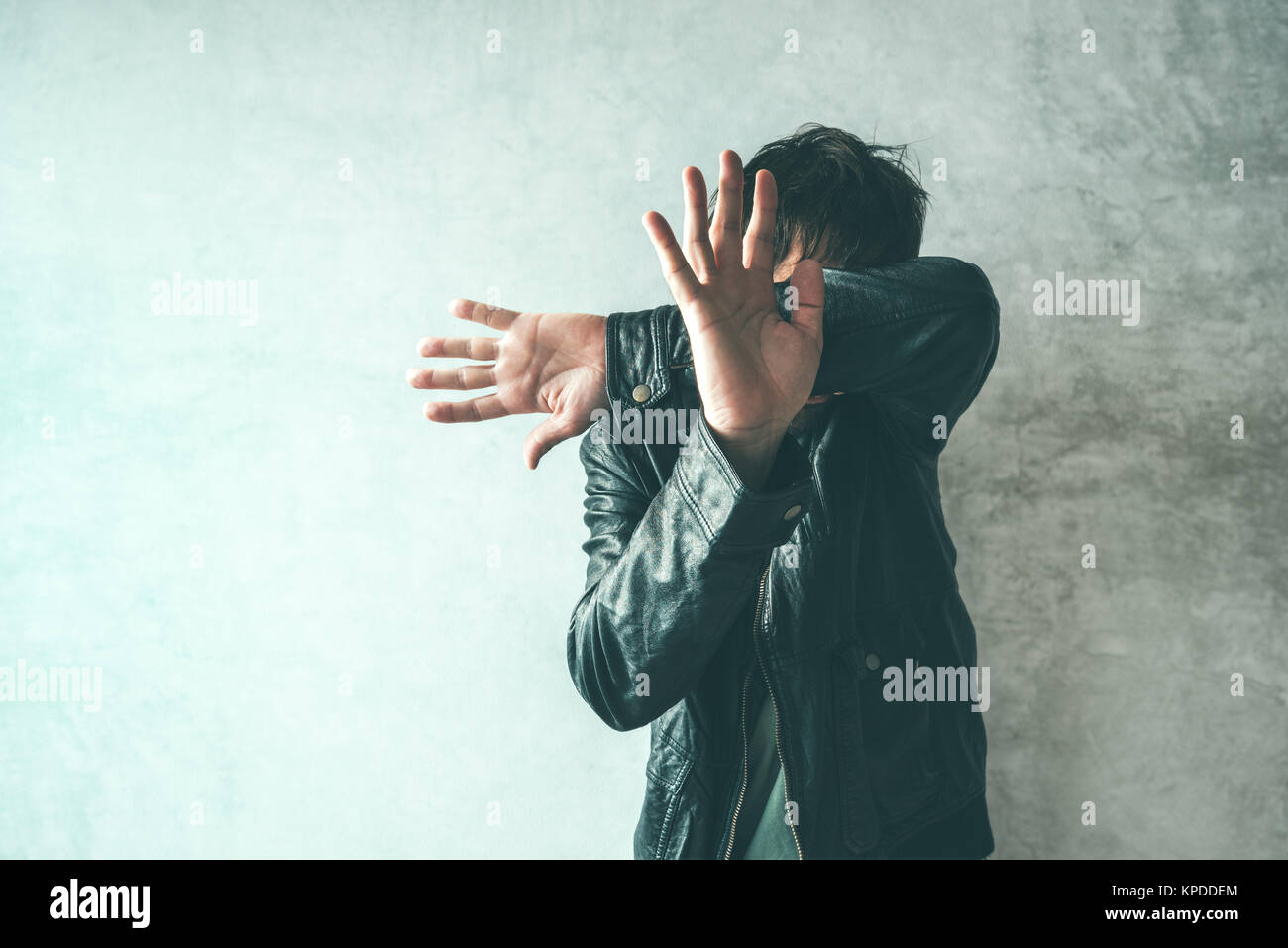 Male protecting face from violent attack. Adult caucasian man covering ...