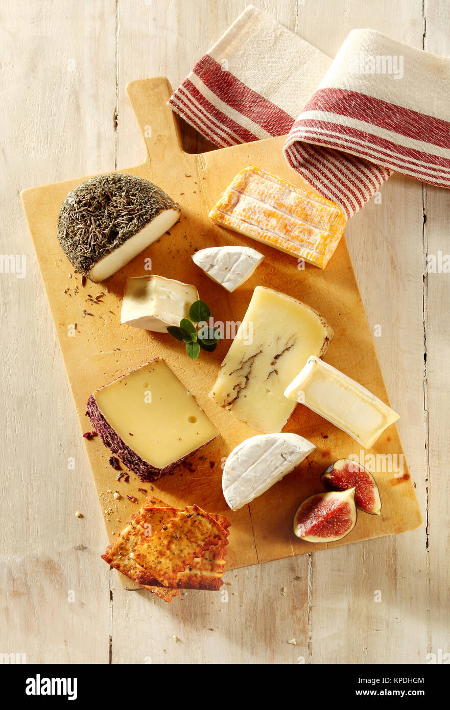 Assortment of soft and semi-hard cheeses on a cheeseboard with sliced ...