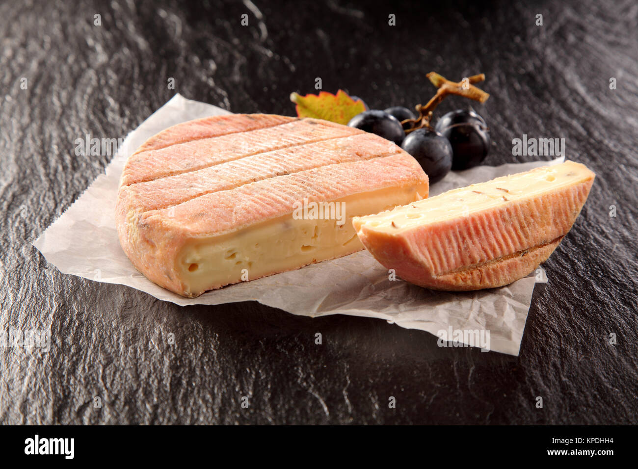 Round of creamy soft aromatic French cheese sliced in half to show the ...