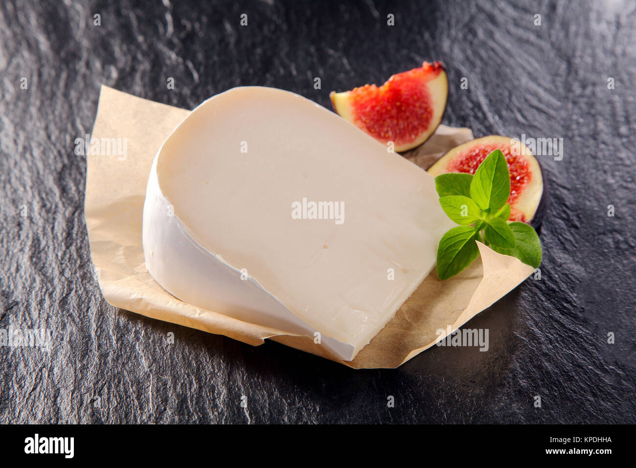 Creamy full milk white goat cheese served in a wedge with sliced ripe ...