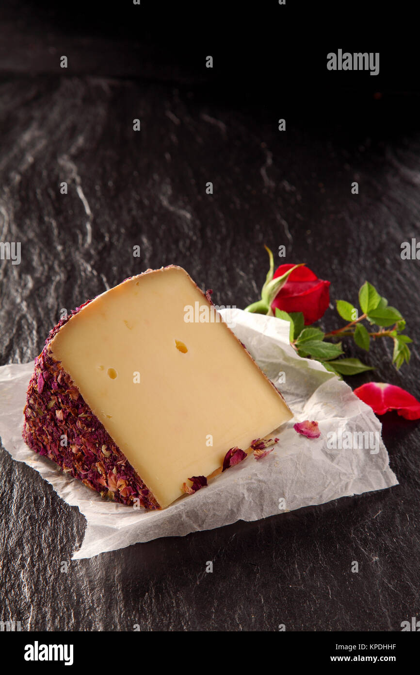 Aromatic gourmet cheese with a dried rose petal covering served on a ...