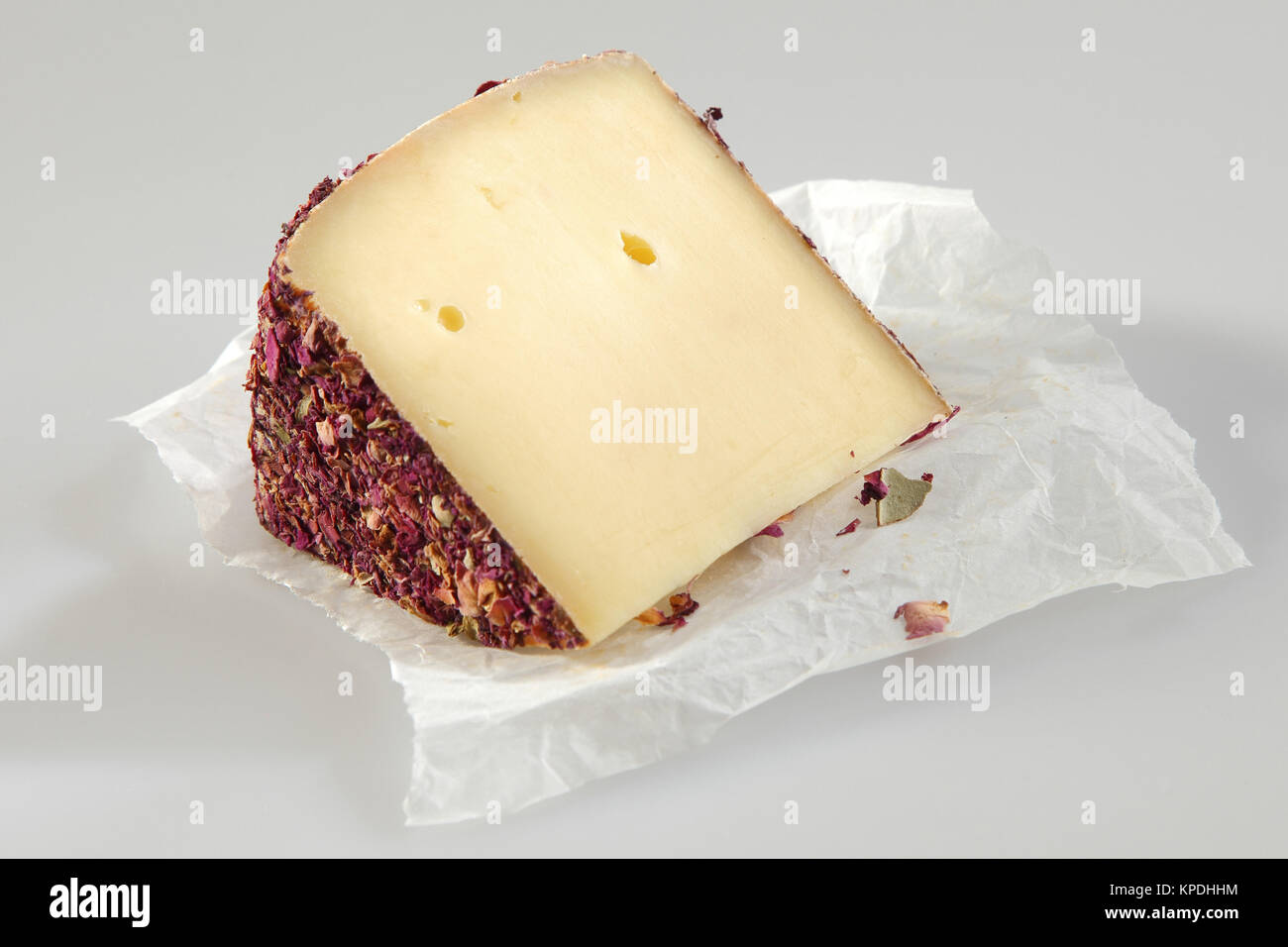Wedge of delicious speciality cheese flavored with rose petals on a ...