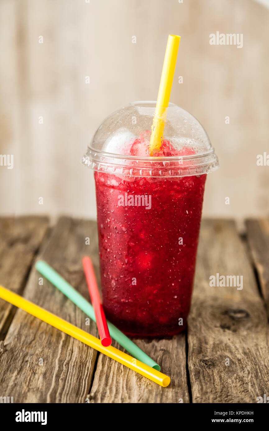frozen red slushie in plastic cup with straw Stock Photo - Alamy