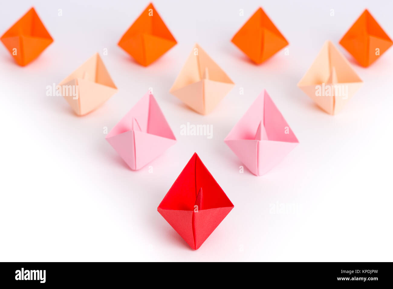 Fleet of origami paper ships in triangle shape isolated on white - like ...