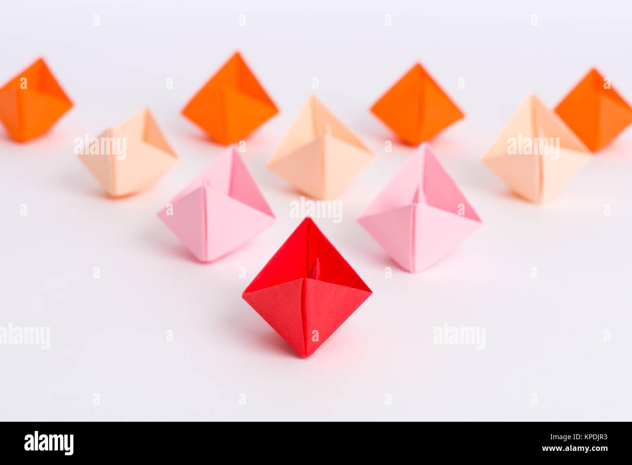 Fleet of origami paper ships in triangle shape isolated on white - like ...