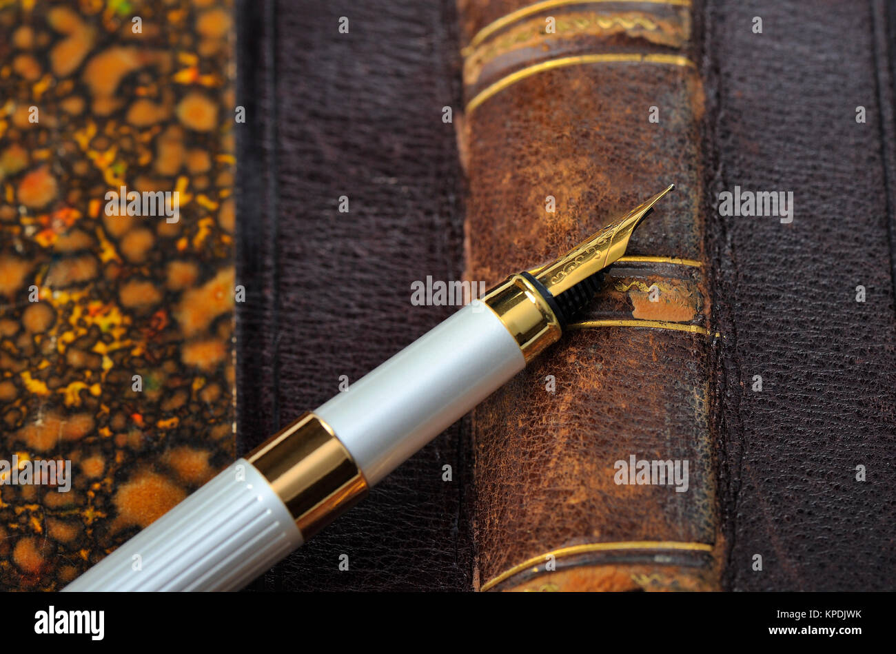 Fountain pen with a gold pen lying on old book, closeup, shallow DOF ...