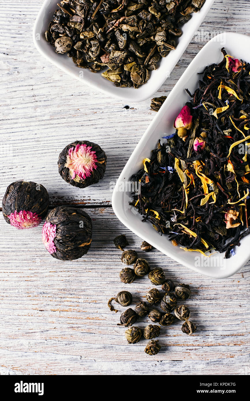 Several types of leaf tea light on a bright wooden background.Top view ...