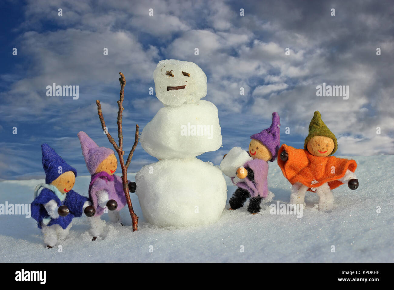 four little elves build a snowman Stock Photo - Alamy