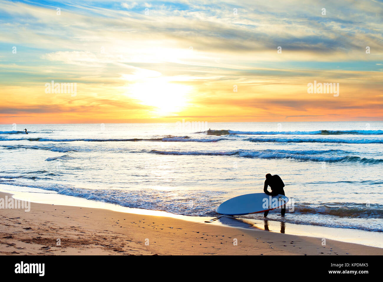 Surfing at sunset Stock Photo - Alamy