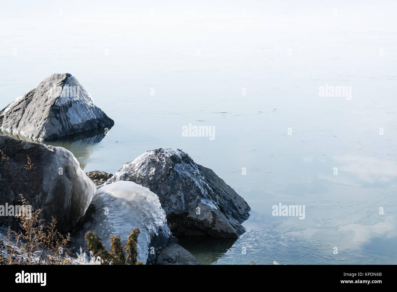 Frozen rocks with ice in the winter lake Stock Photo - Alamy