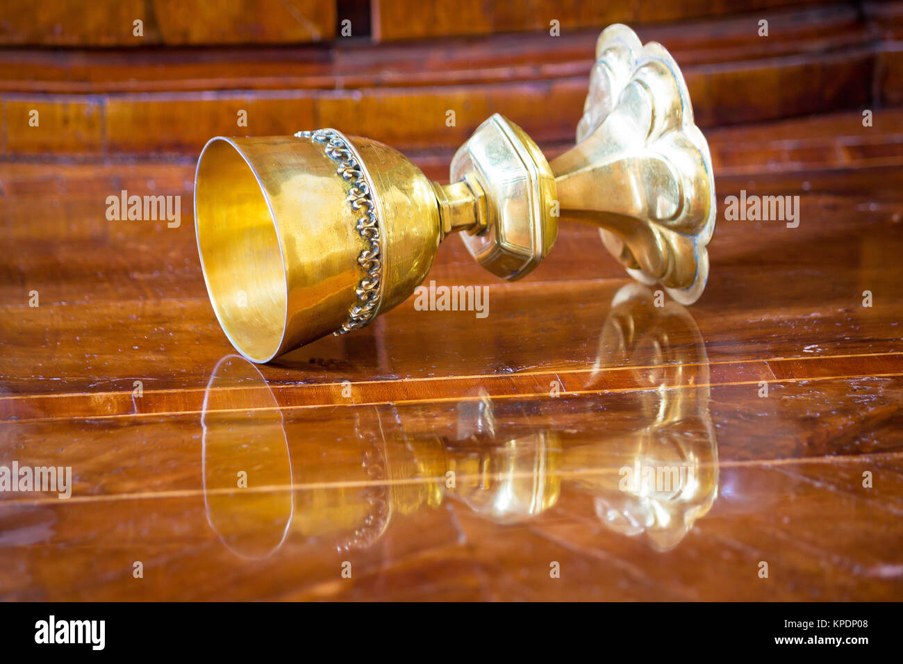 Golden grail turned on wooden background Stock Photo - Alamy