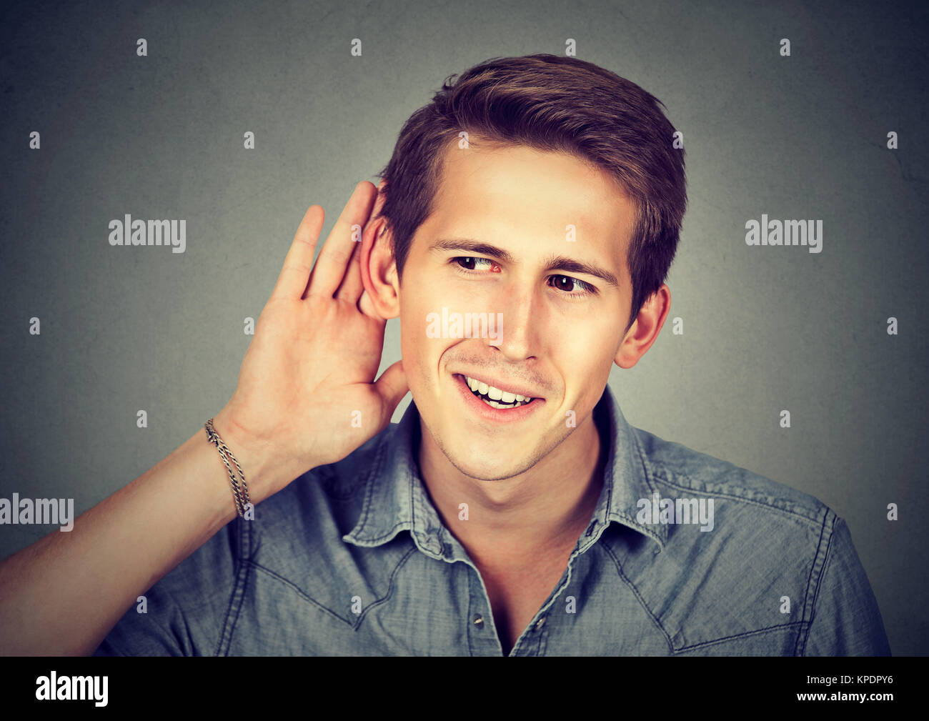 Young man looking content while collecting rumors and gossip Stock ...