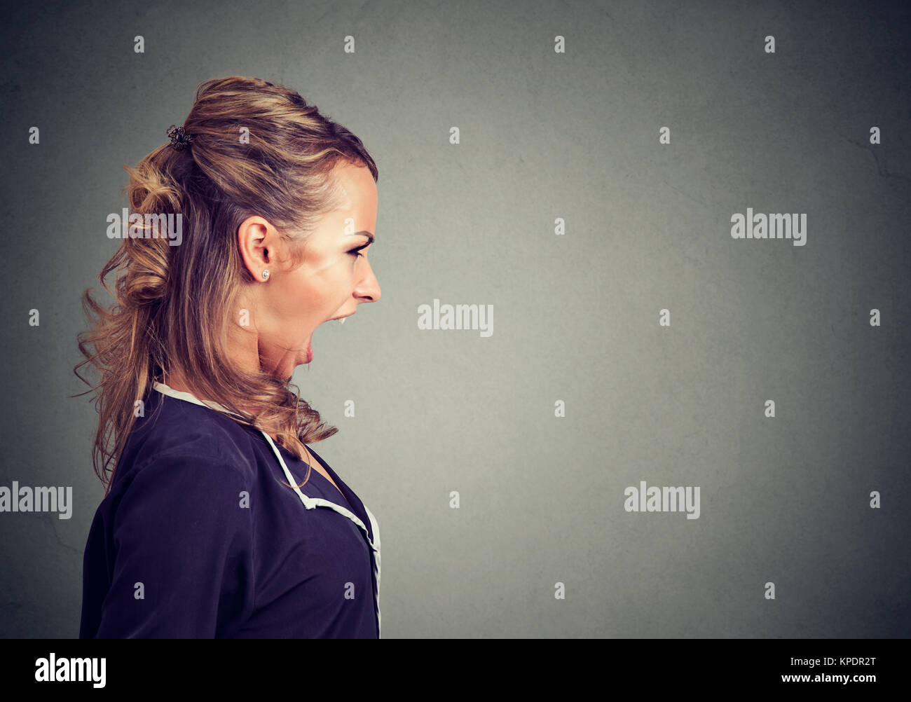 Side view of woman shouting angrily with fierce expression looking away ...