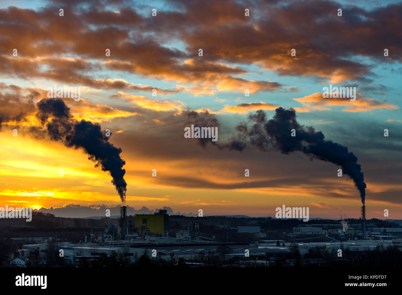 Sunrise silhouette of smoking factory Stock Photo - Alamy