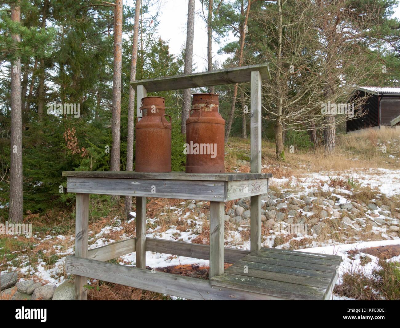 two old rusty milk jug on a bench Stock Photo - Alamy
