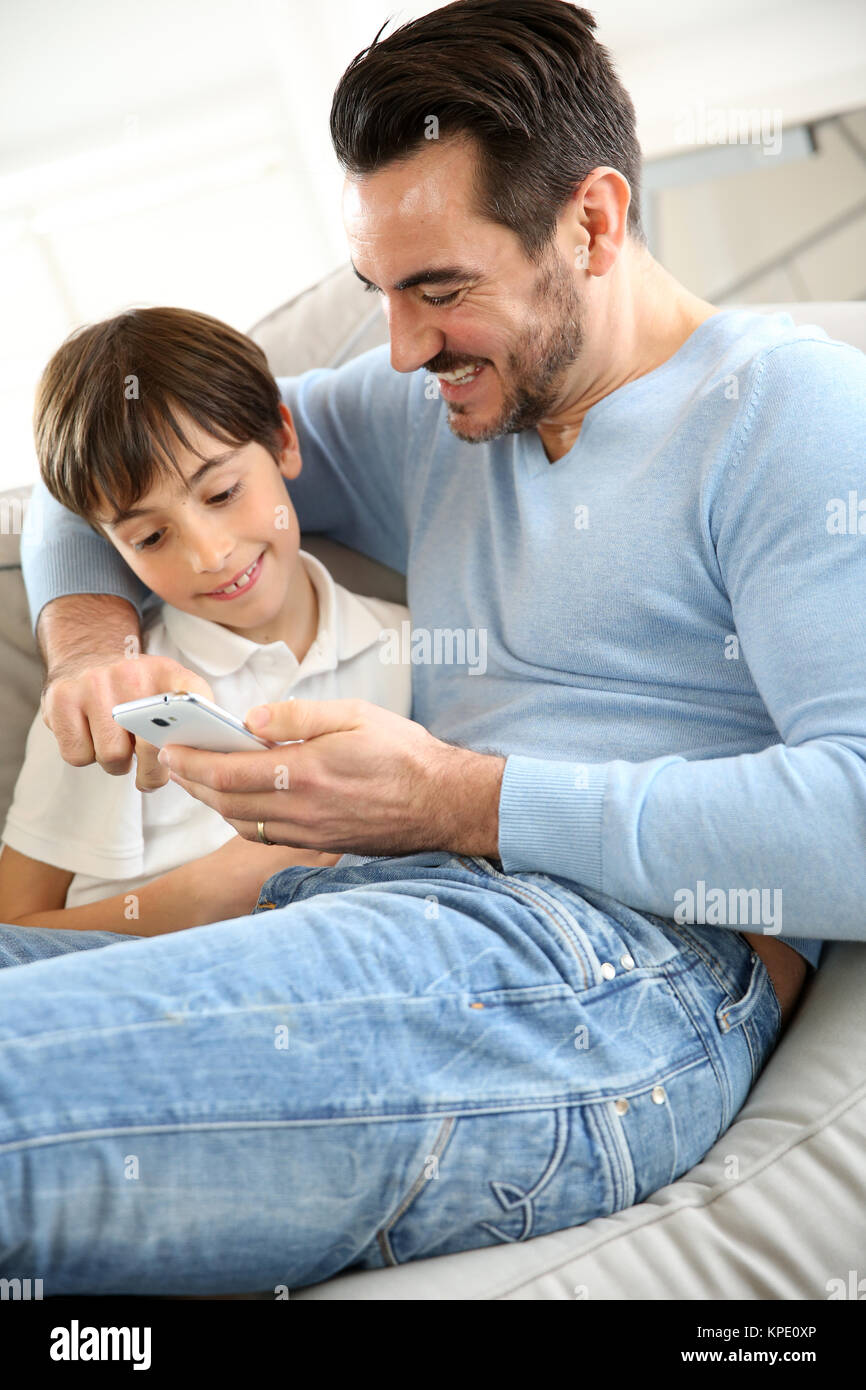 Little boy with dad playing with smartphone Stock Photo - Alamy