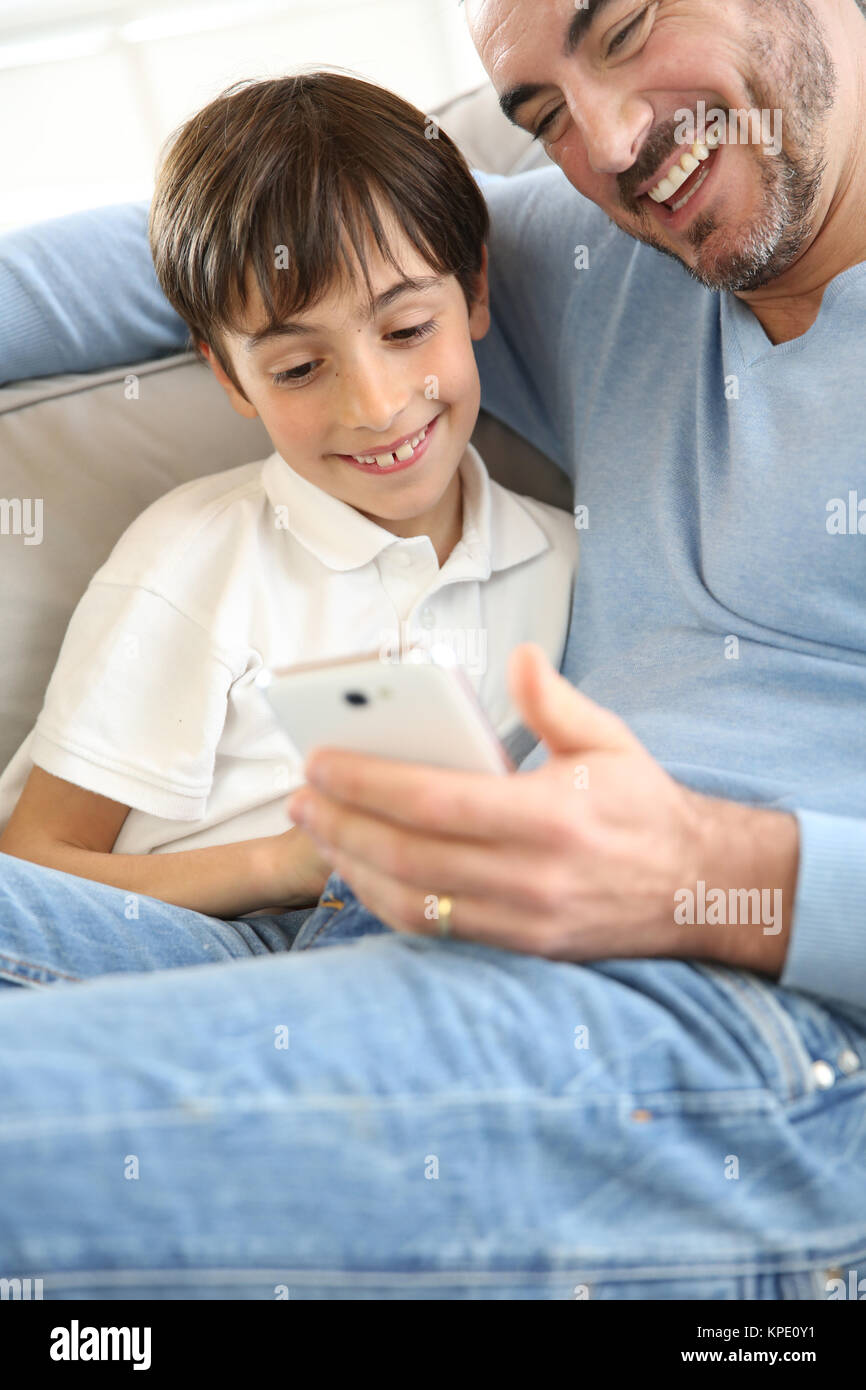 Little boy with dad playing with smartphone Stock Photo - Alamy