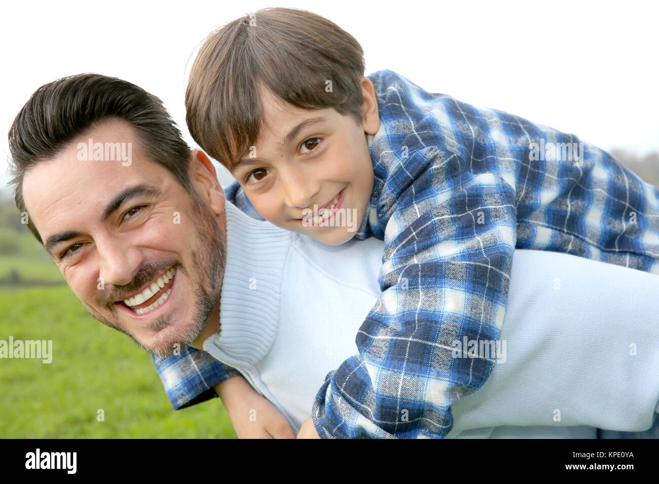 Man holding son on her back Stock Photo - Alamy