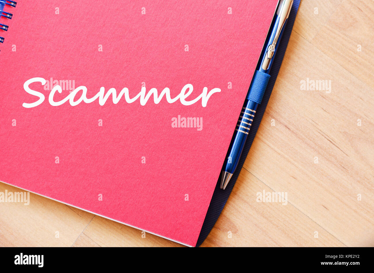 Scammer write on notebook Stock Photo - Alamy