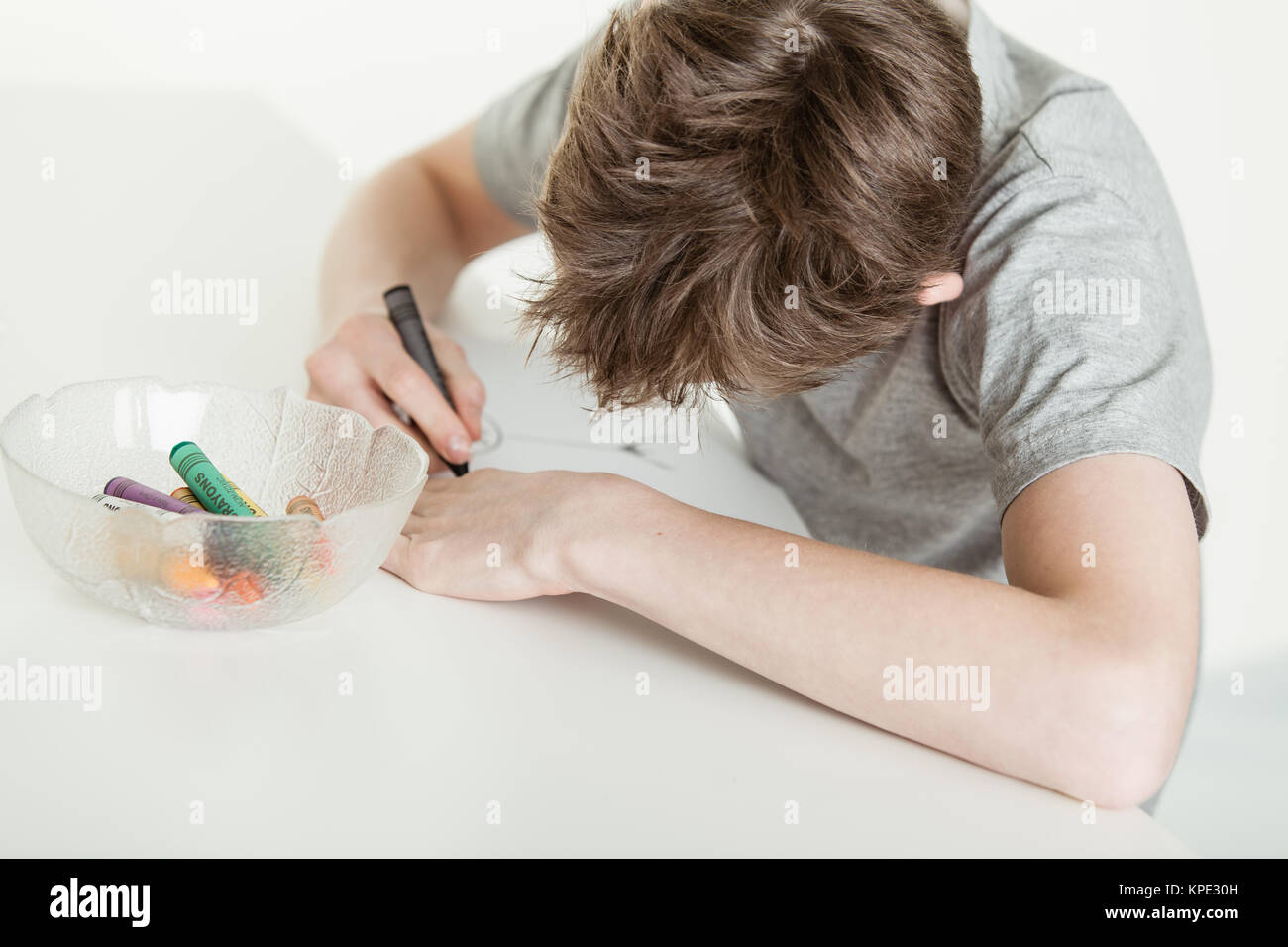Young Boy Coloring his Drawing using Crayons Stock Photo - Alamy