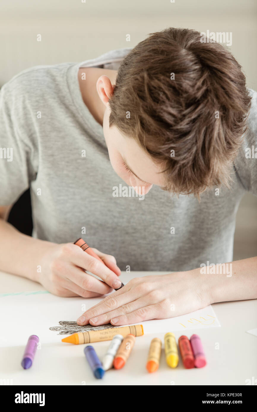 Young Boy Drawing on White Paper with Crayons Stock Photo - Alamy