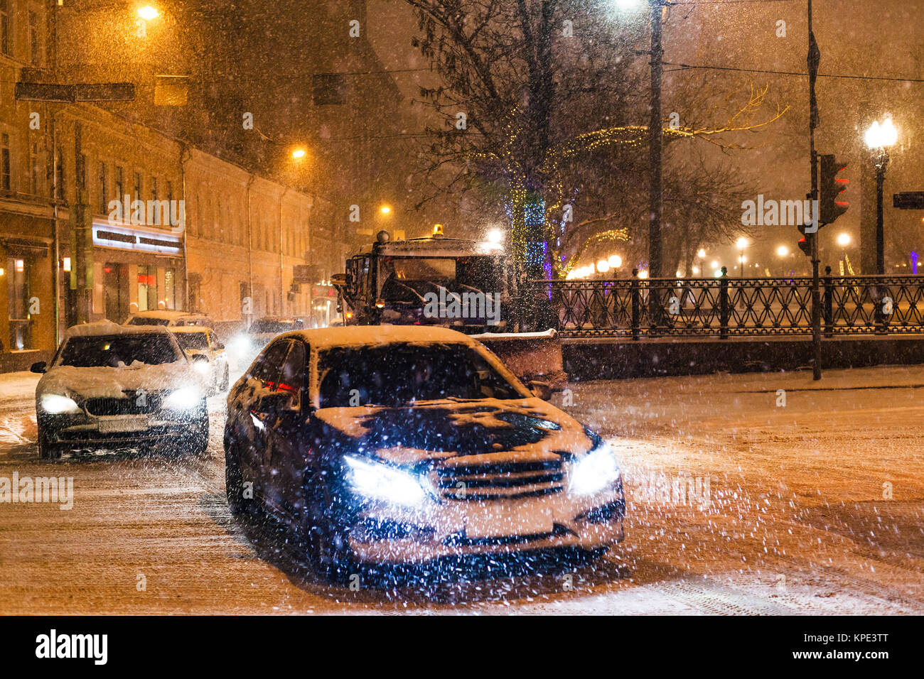 snowfall in night city - cars traffic under snow Stock Photo - Alamy