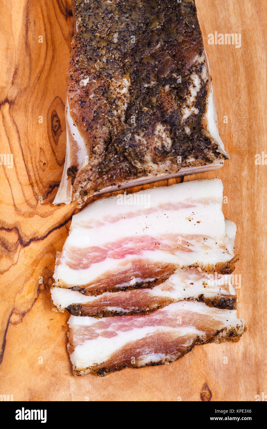 top view of piece and few slices of bacon on board Stock Photo - Alamy