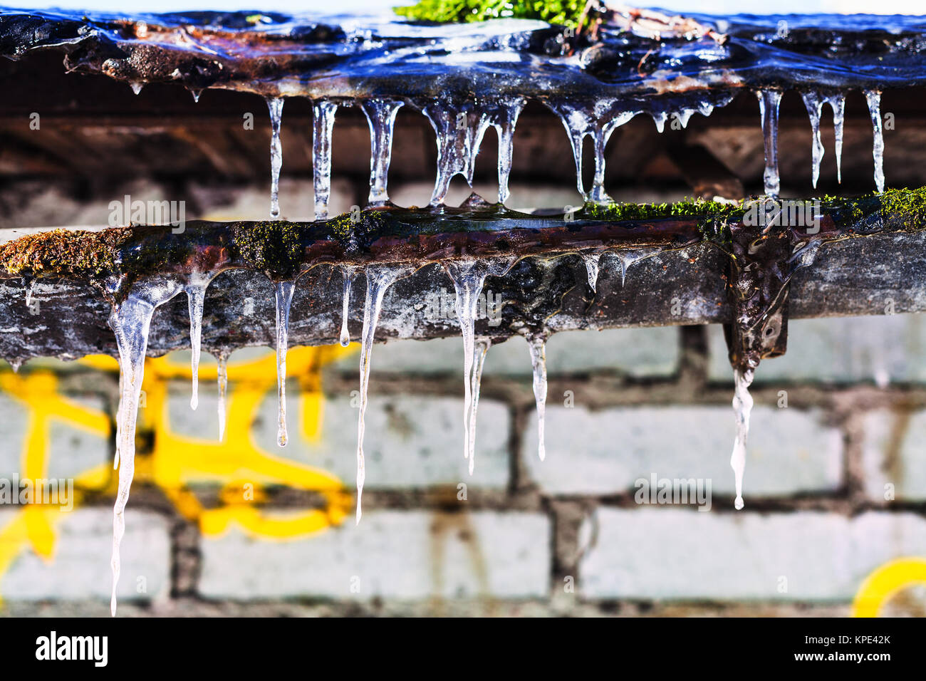 icicles on old gully of house with brick wall Stock Photo - Alamy
