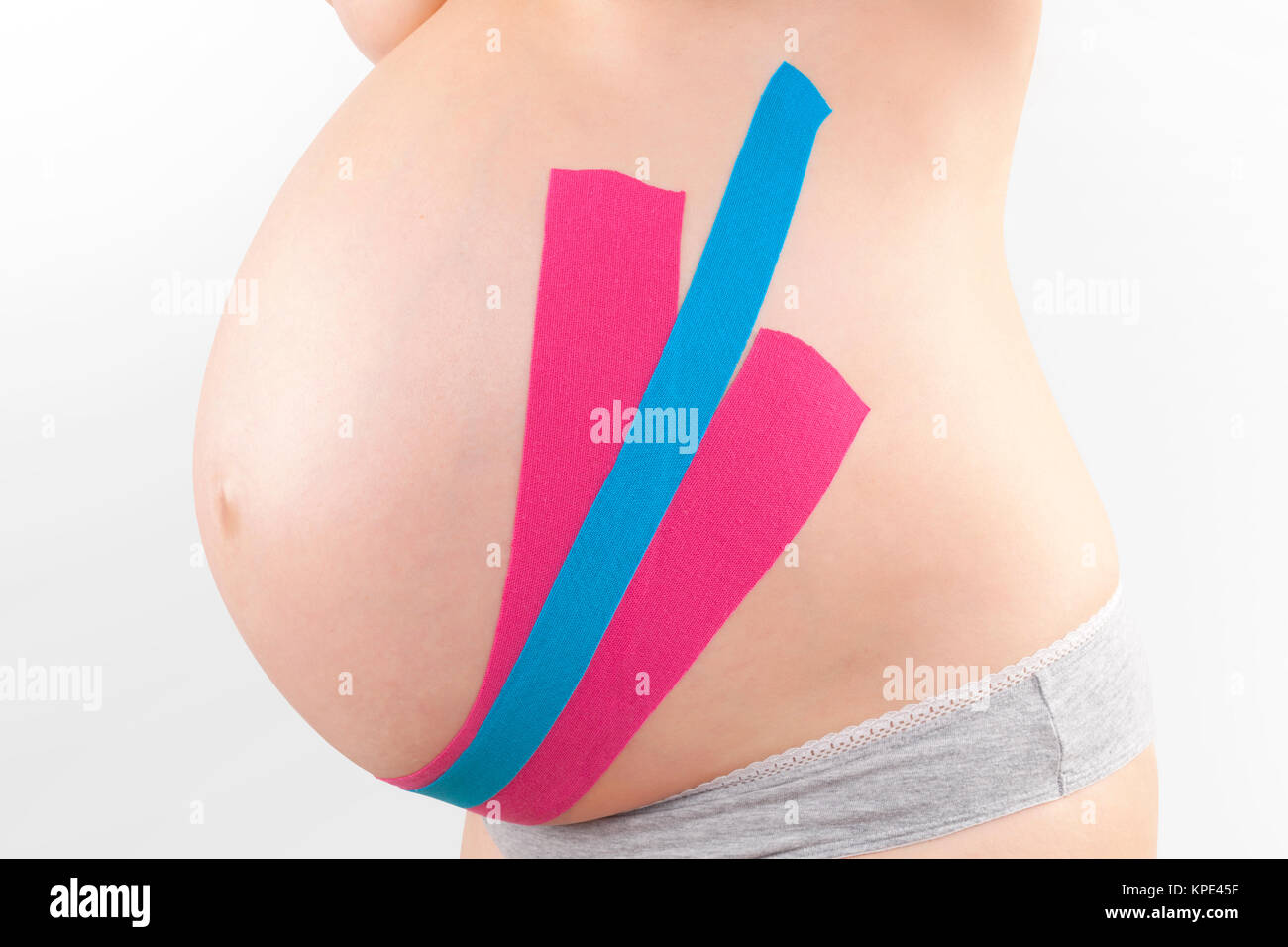 Beautiful pregnant woman with kinesio tape. Back pain in pregnancy, alternative kinesio tape ...
