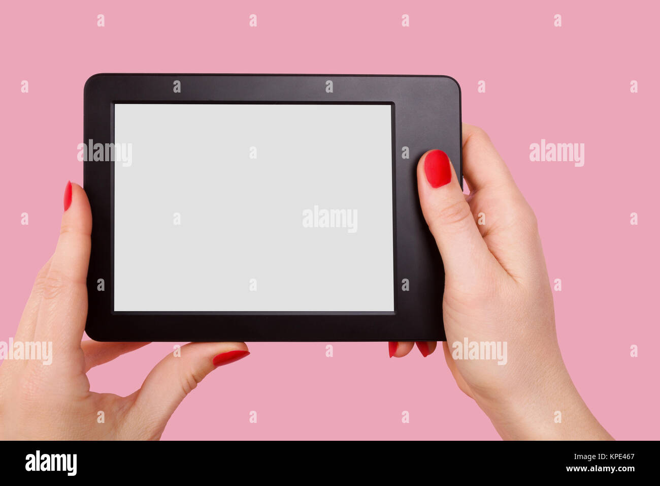 Female hand holding e reader isolated on pink background. Reading ...