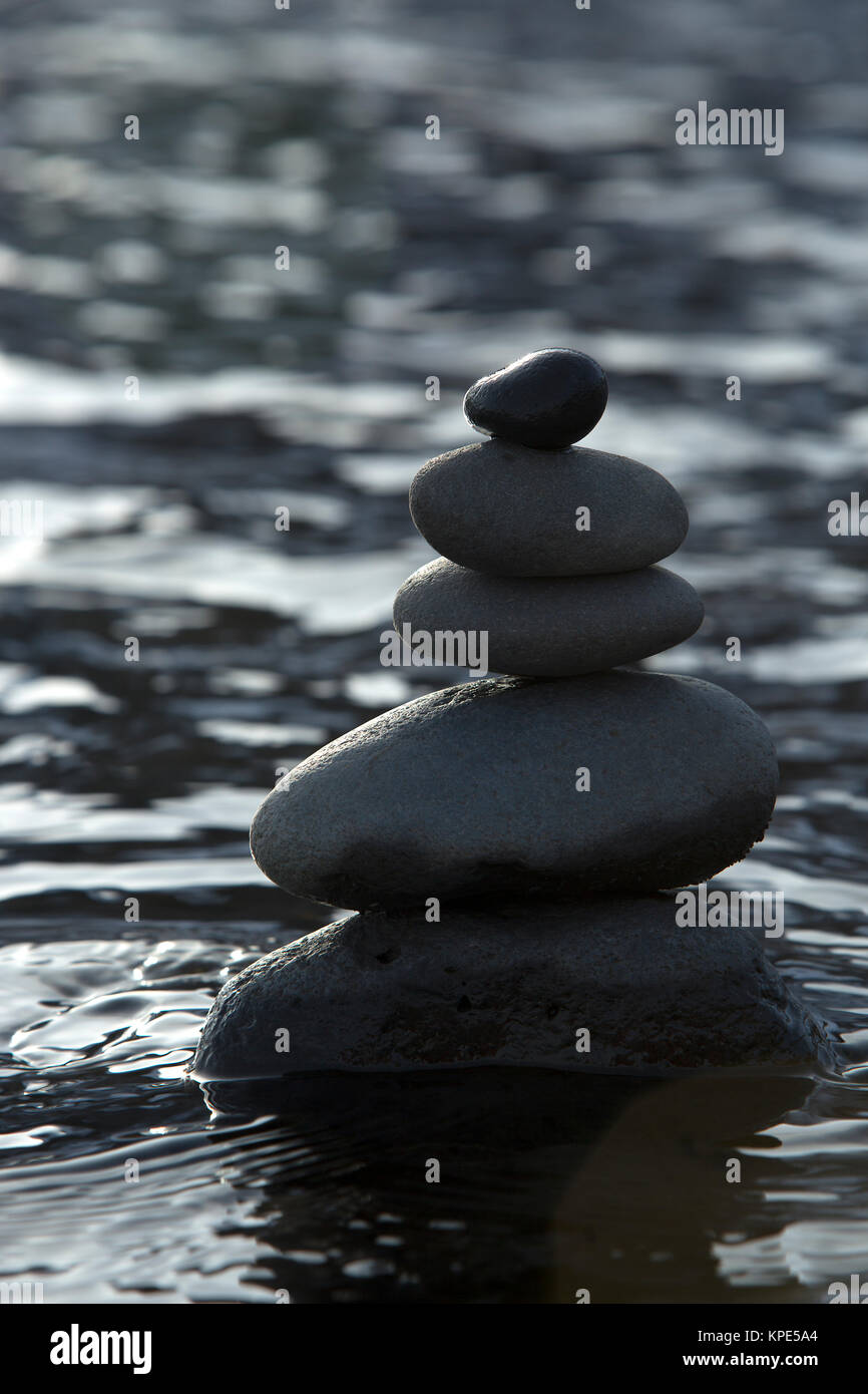 Stacked stones in water with backlit Stock Photo - Alamy