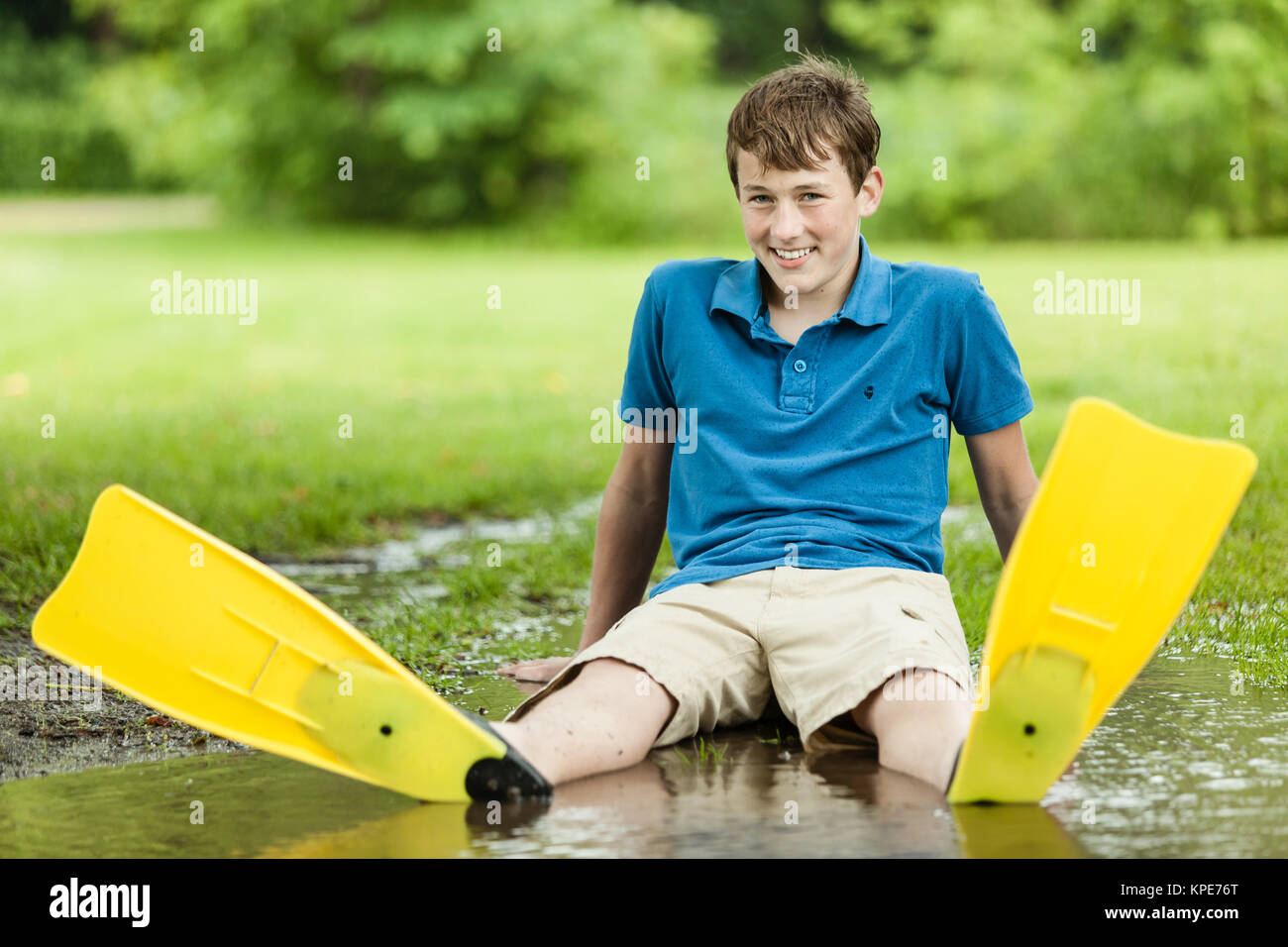 Happy teenager sitting in large puddle Stock Photo - Alamy