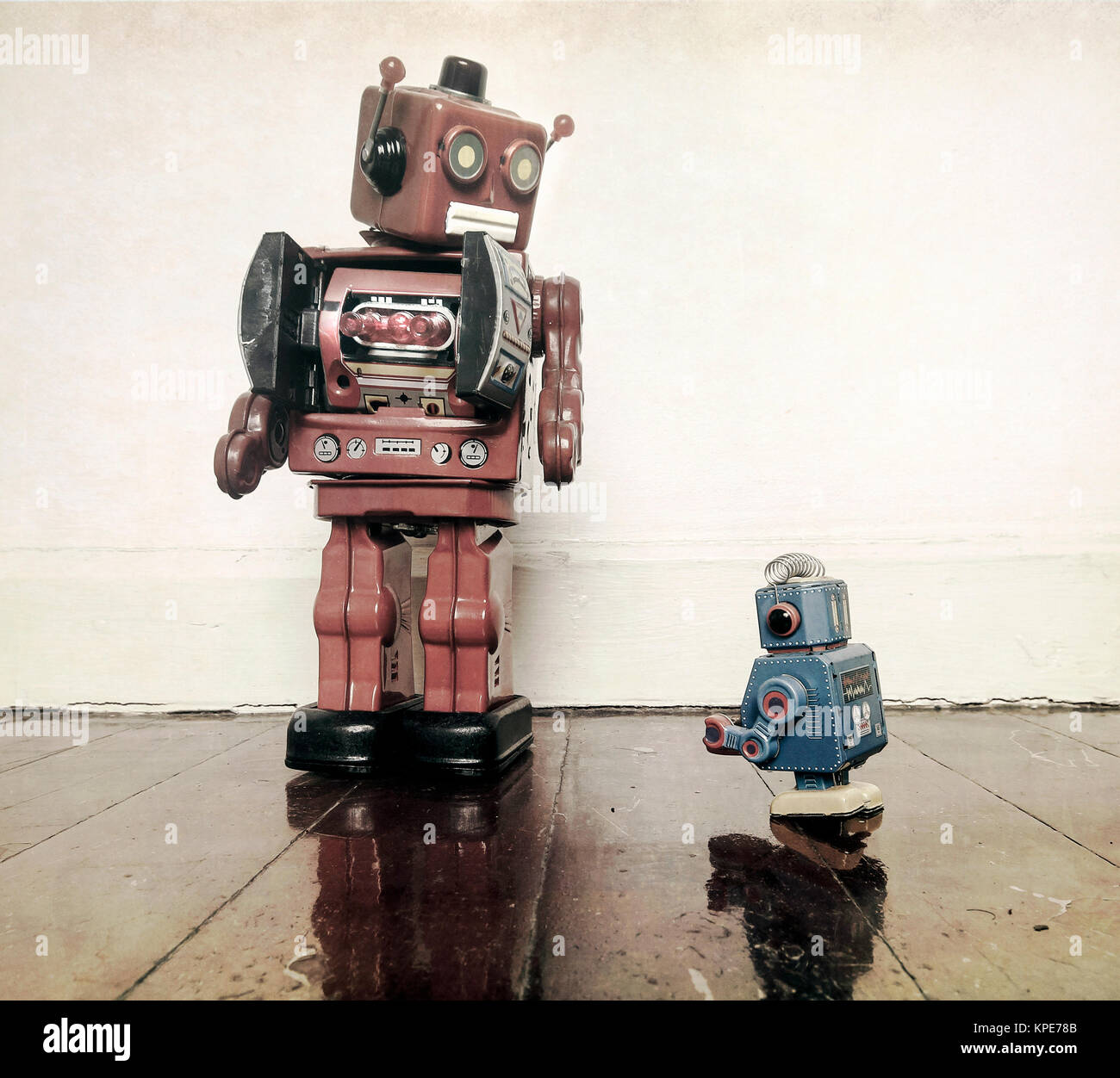 Boss robots looking down on his working robot on wooden floor with ...
