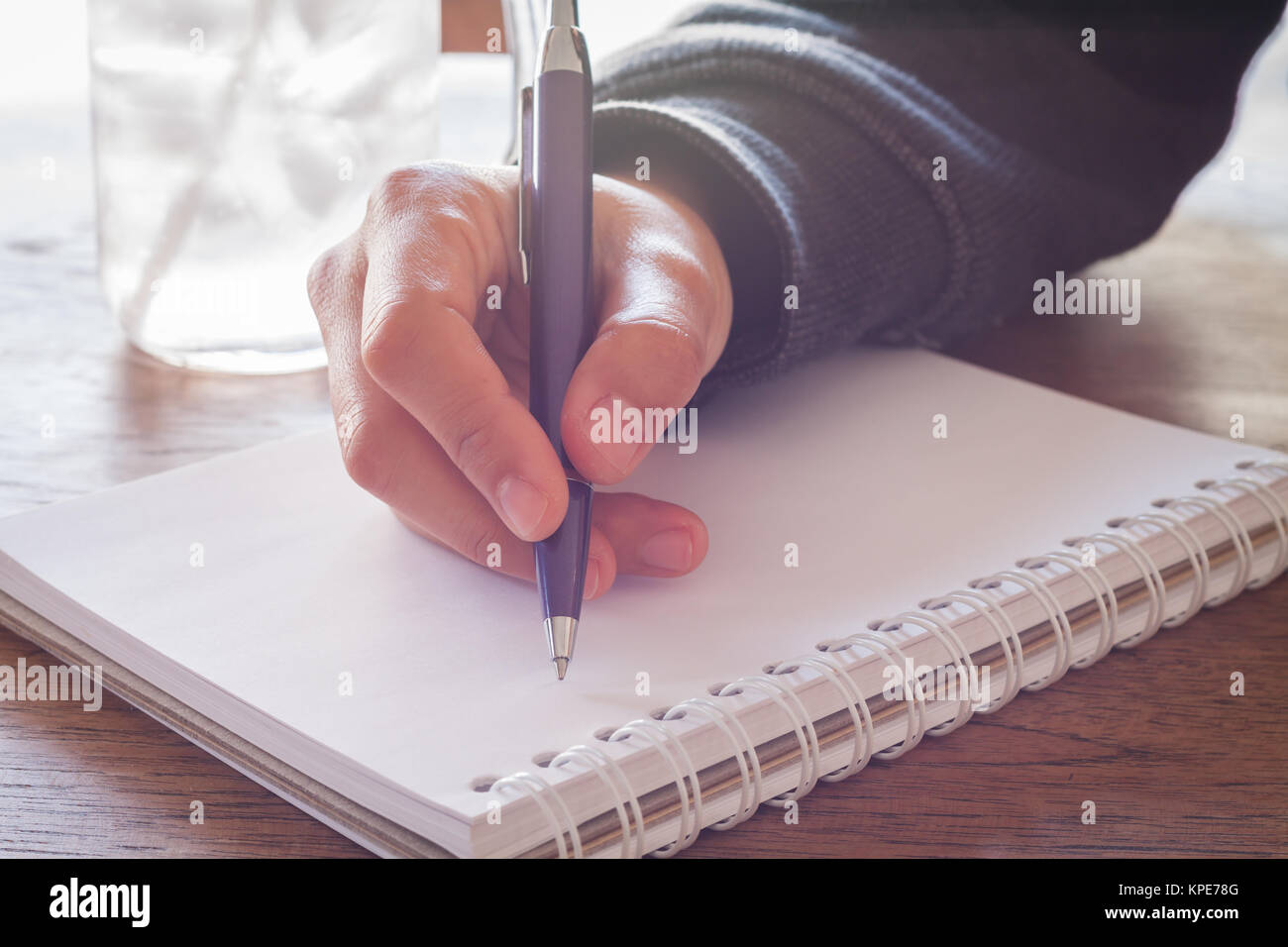 Woman hand with pen writing on notebook Stock Photo - Alamy