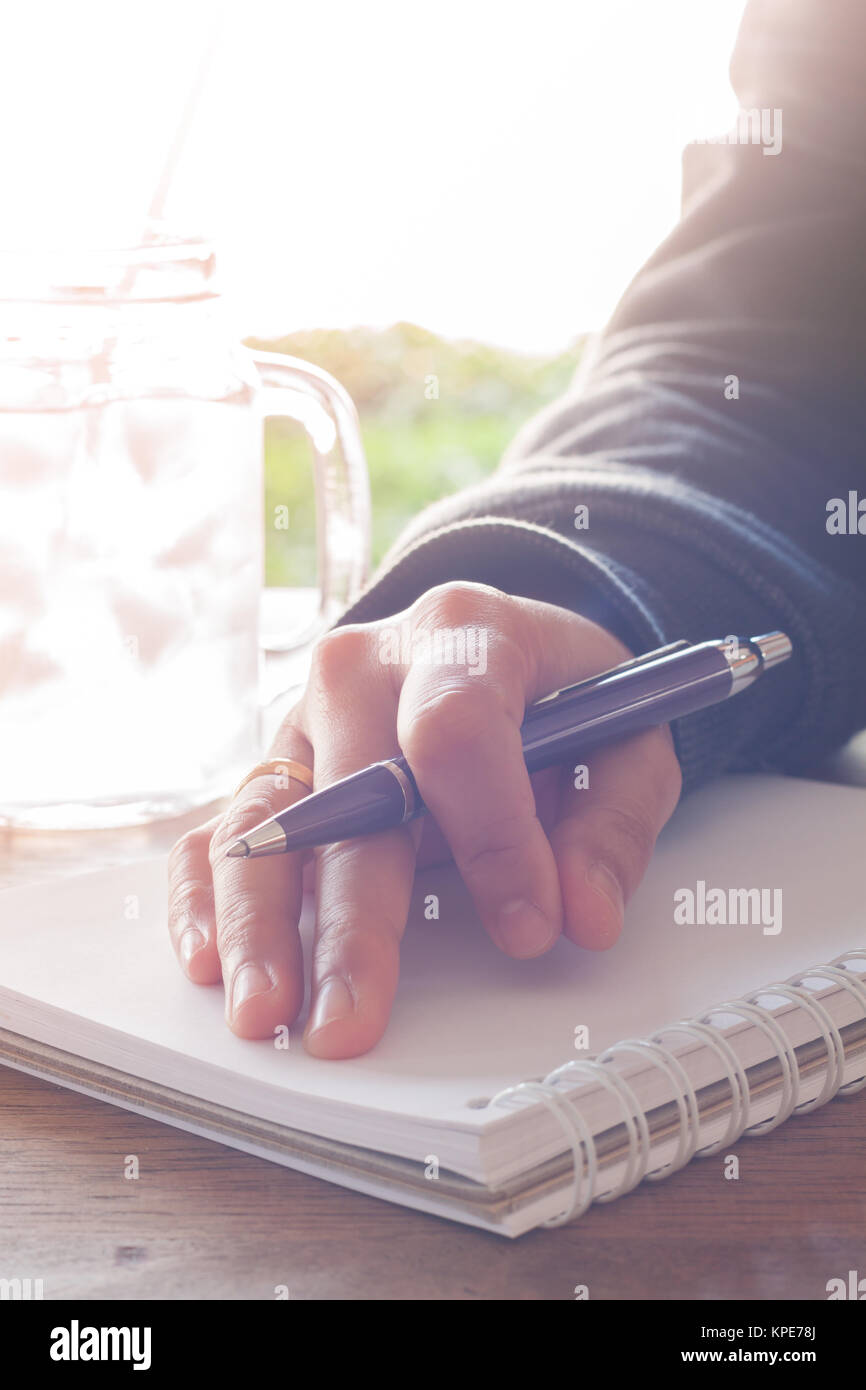 Woman hand with pen writing on notebook Stock Photo - Alamy