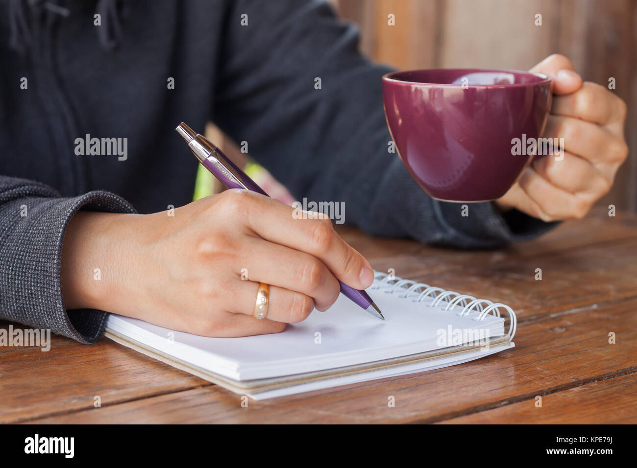 Woman hand with pen writing on notebook Stock Photo - Alamy