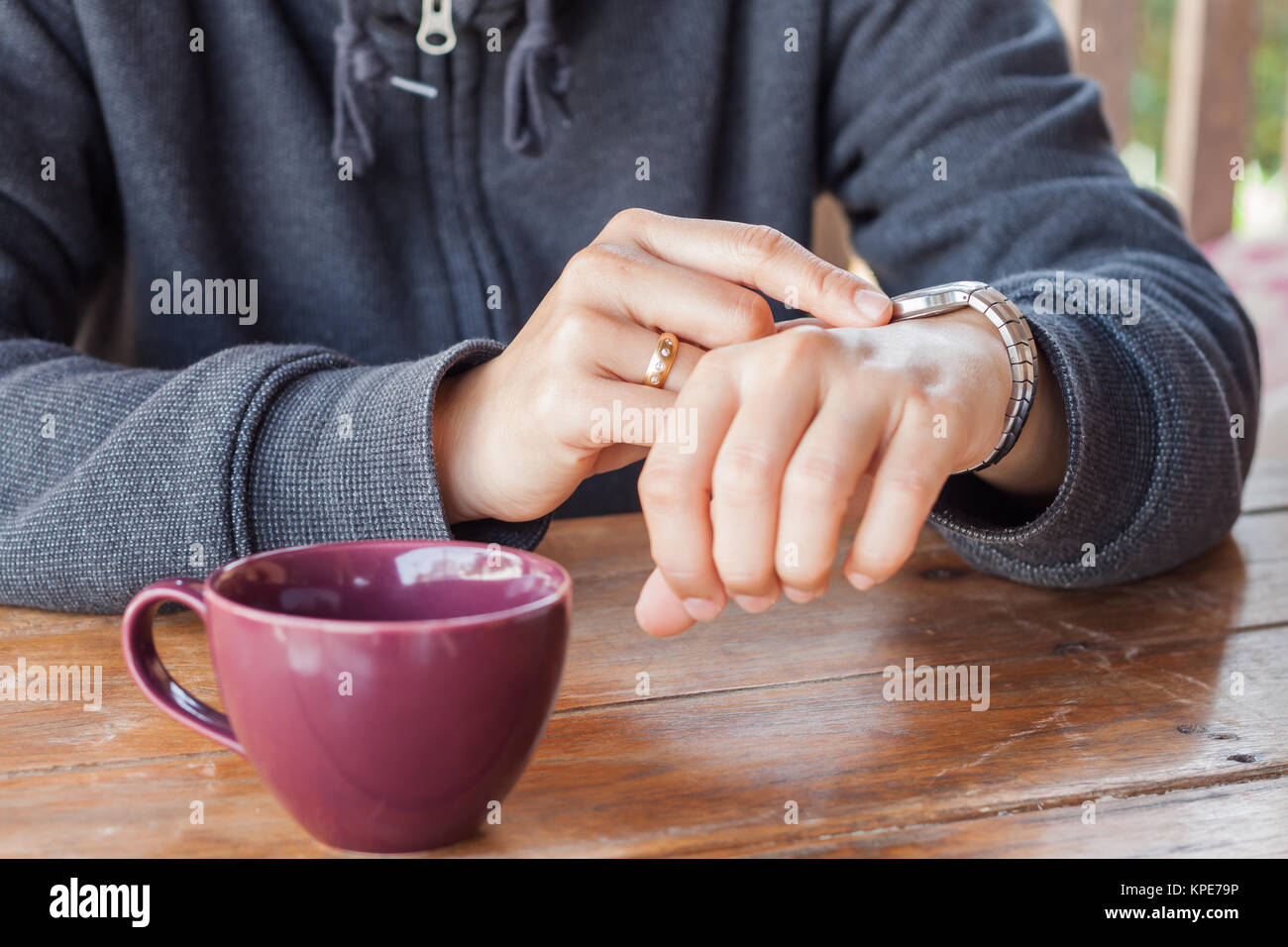 Woman checks the time on a wrist watch Stock Photo - Alamy