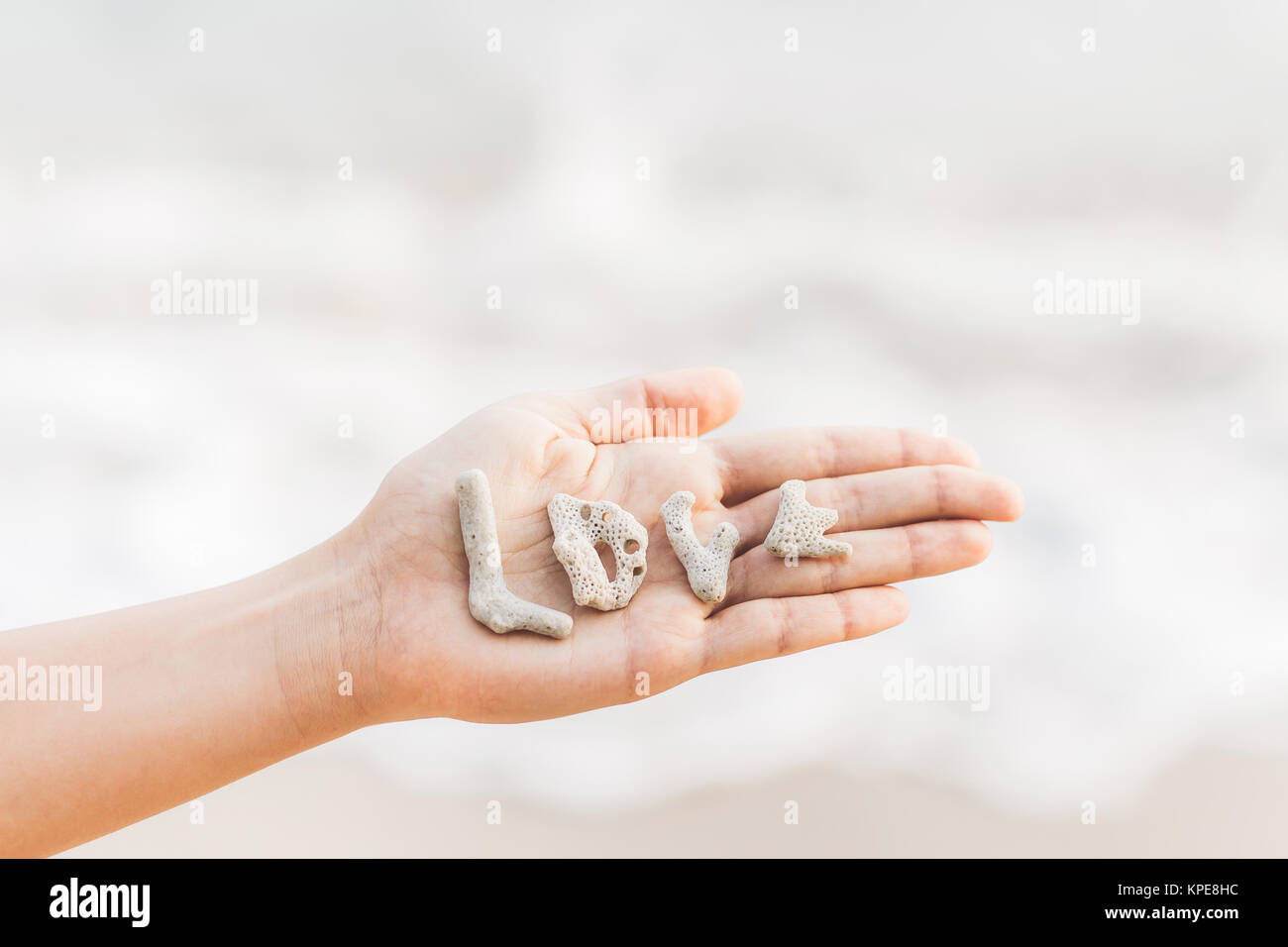 Word love made of shells on woman hand Stock Photo - Alamy