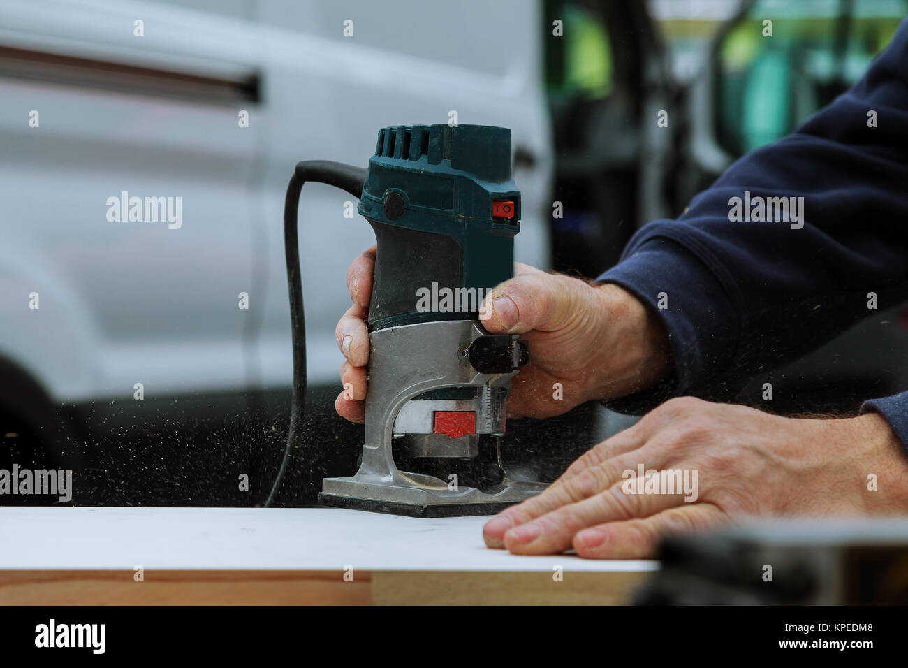 workers using electric routering to cut down stripes on the wood Stock ...