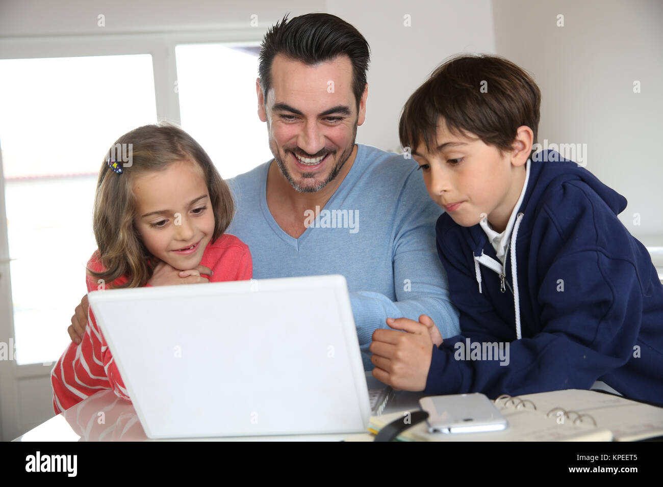 Man with children using laptop at home Stock Photo - Alamy