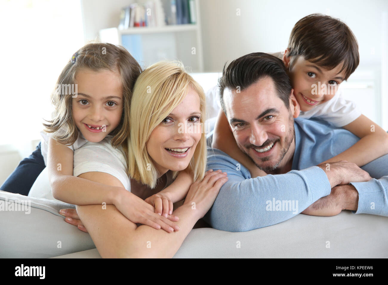 Family of four sitting in sofa at home Stock Photo - Alamy
